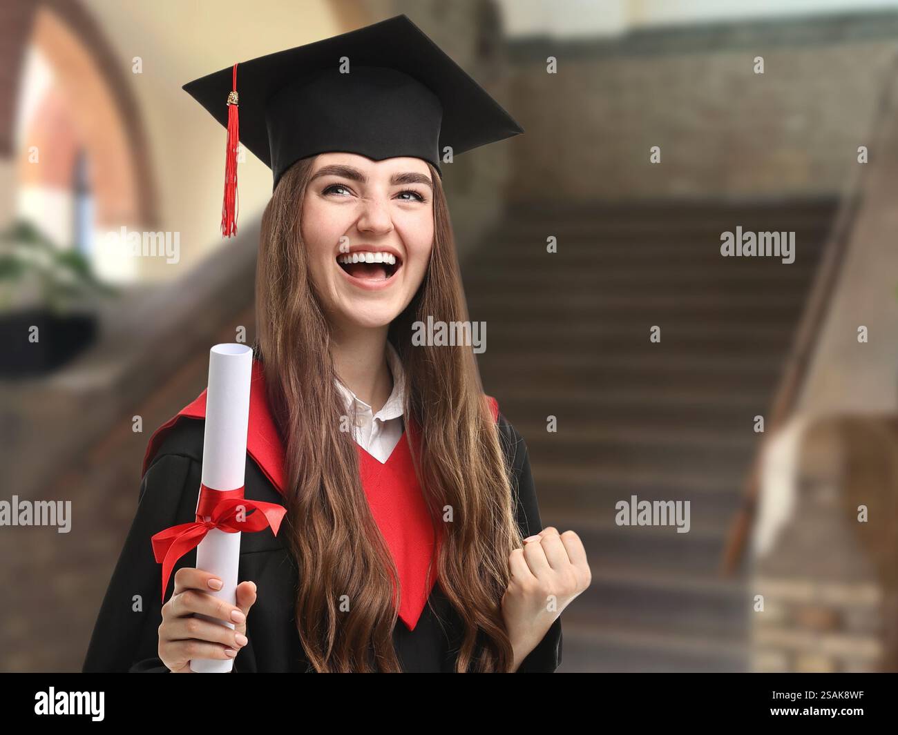 Happy student in academic dress holding diploma after graduation in ...
