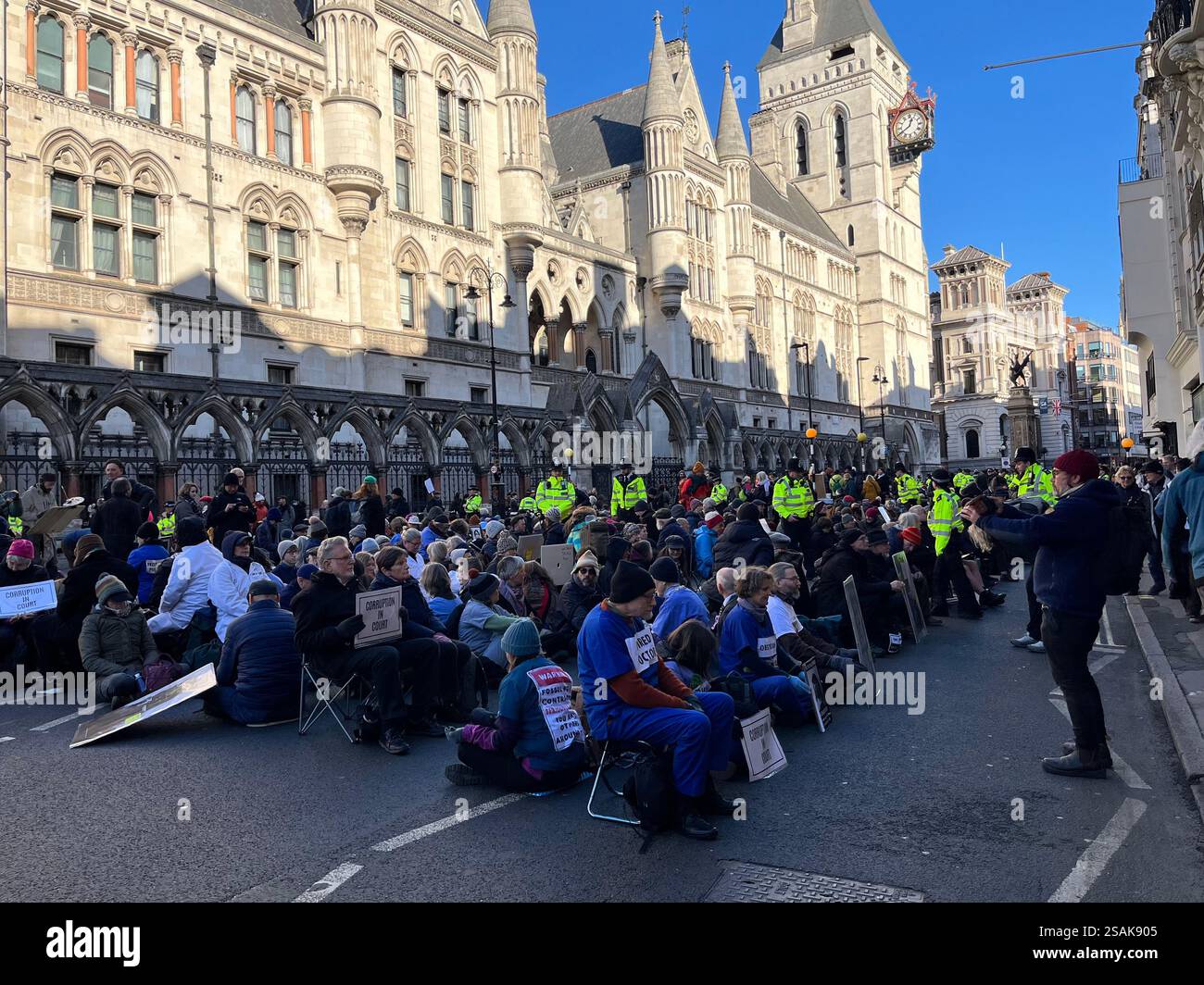 Campaigners stage a sit-down protest outside the Royal Courts of ...