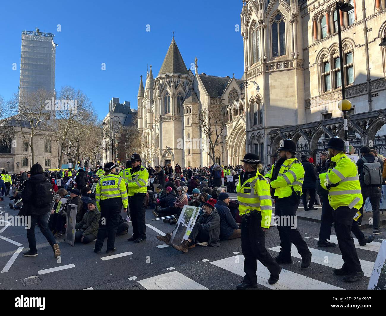 Campaigners stage a sit-down protest outside the Royal Courts of ...