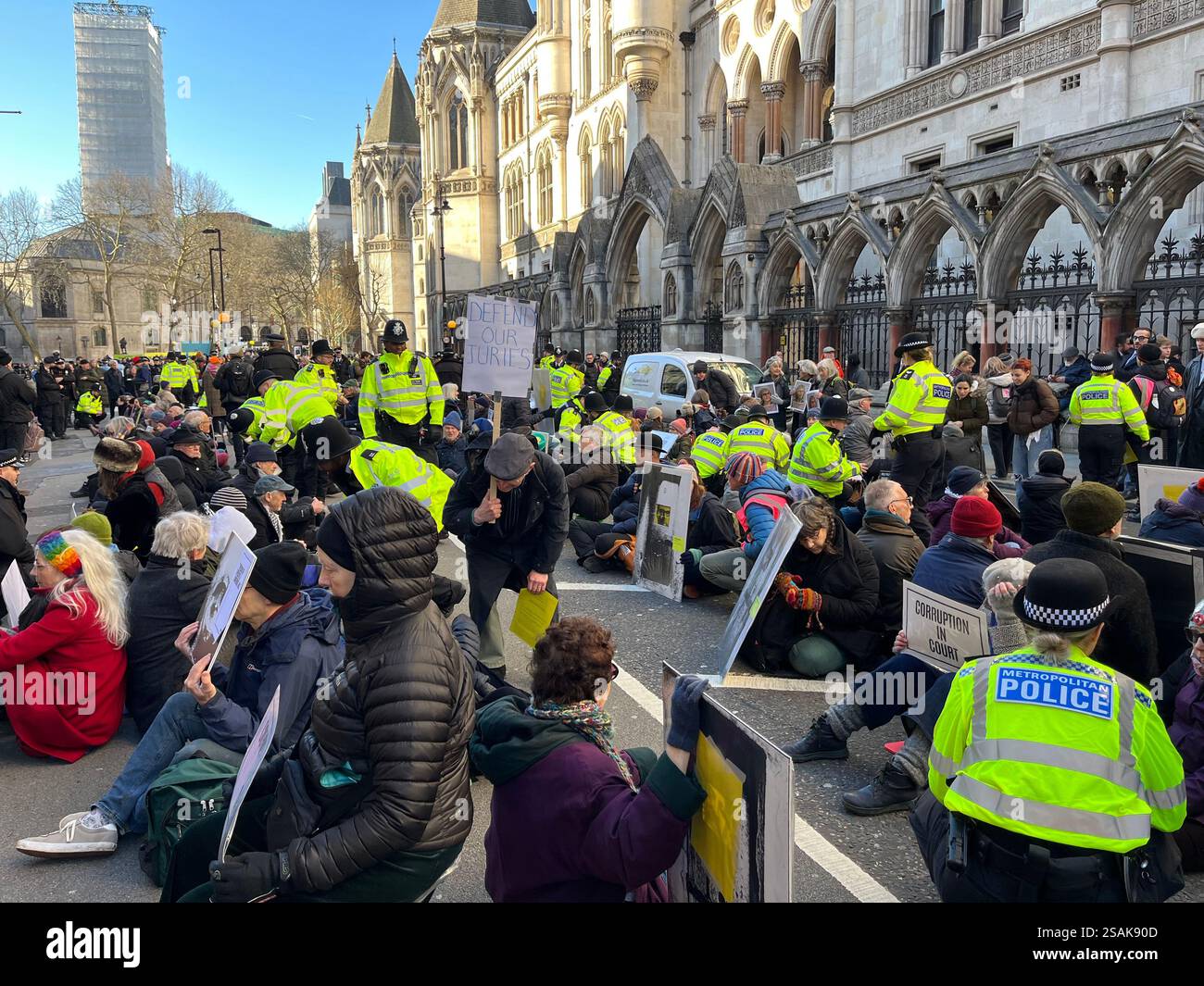 Campaigners stage a sit-down protest outside the Royal Courts of ...