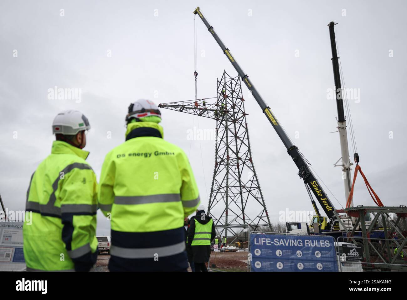 Altenkrempe, Germany. 30th Jan, 2025. Employees of a specialist company assemble a pylon for the ...