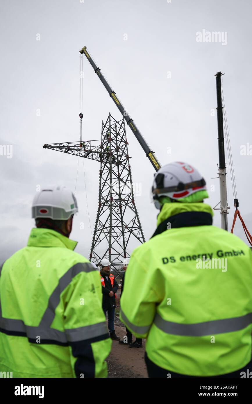 Altenkrempe, Germany. 30th Jan, 2025. Employees of a specialist company assemble a pylon for the ...