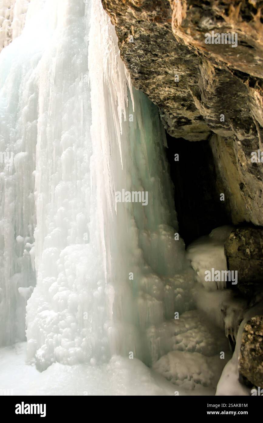 A large icicle hangs from the ceiling of a cave. The icicle is ...