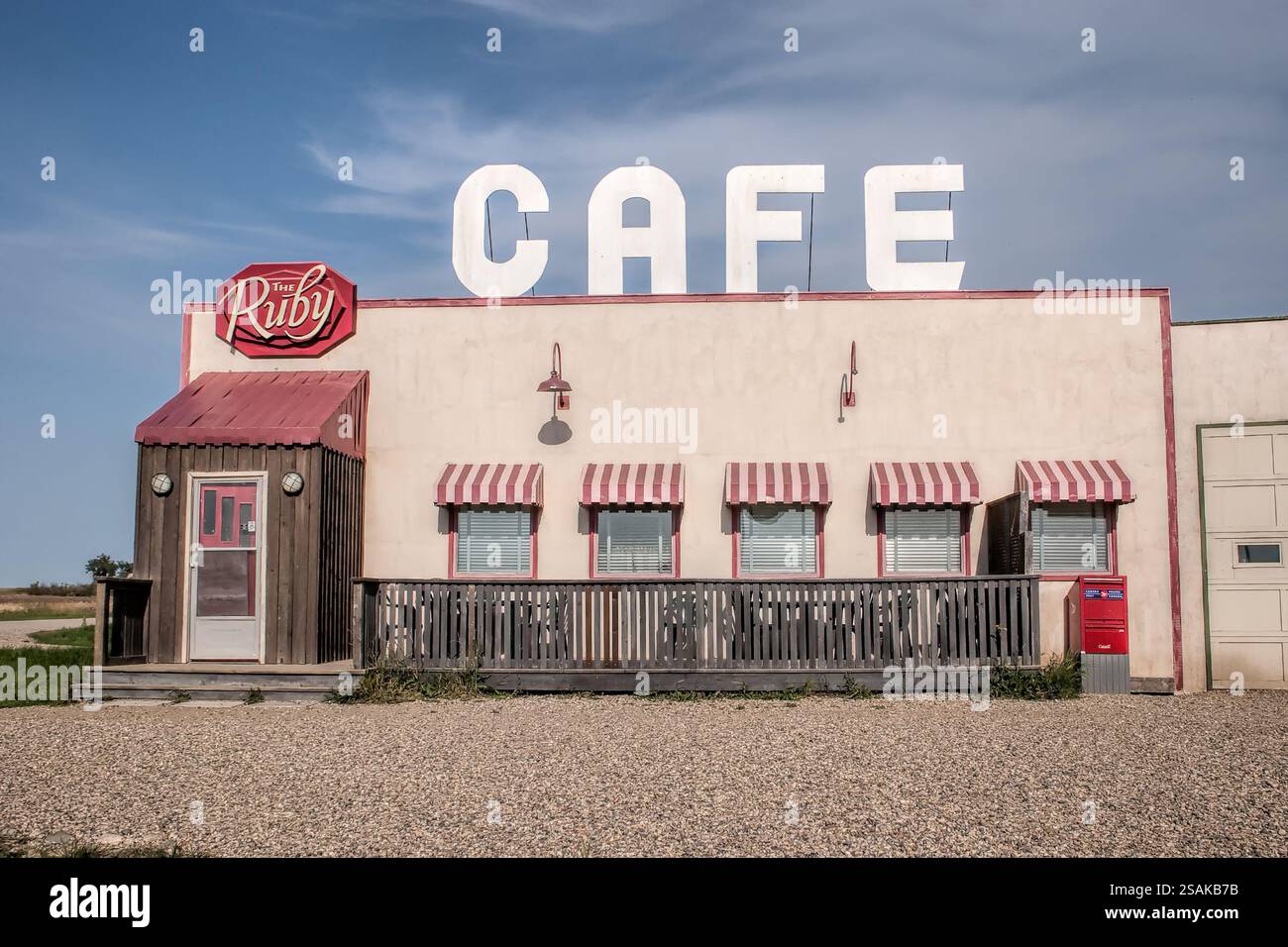 A cafe with a red and white sign on the front. The cafe is empty. There ...
