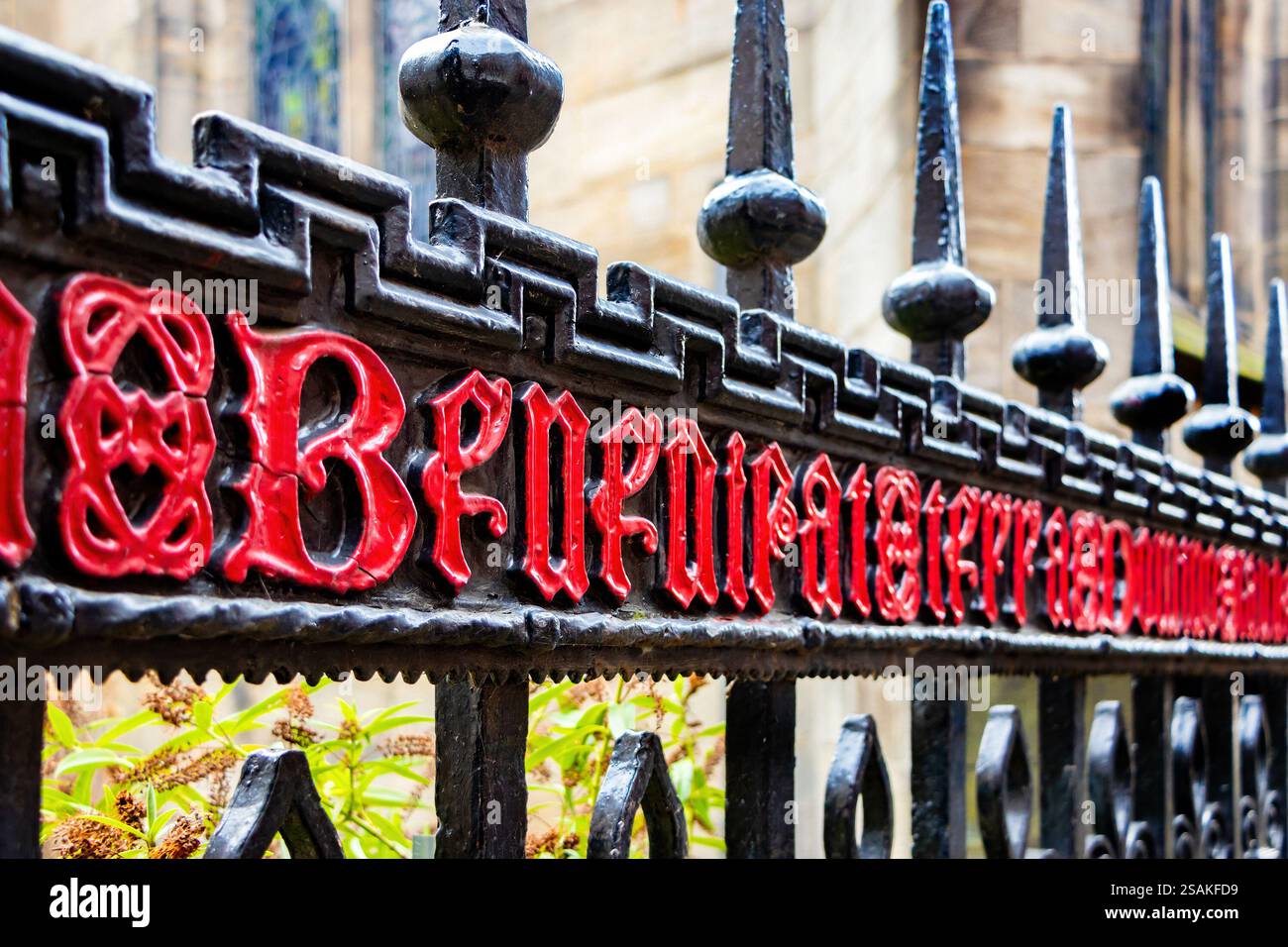 intricate red medieval text on black cast iron railings in newcastle ...