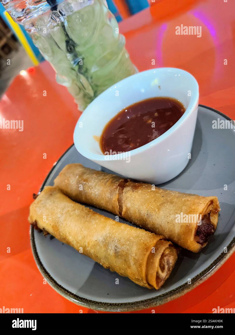 Golden Spring Rolls with Dipping Sauce and Iced Drink Eye-Level View ...