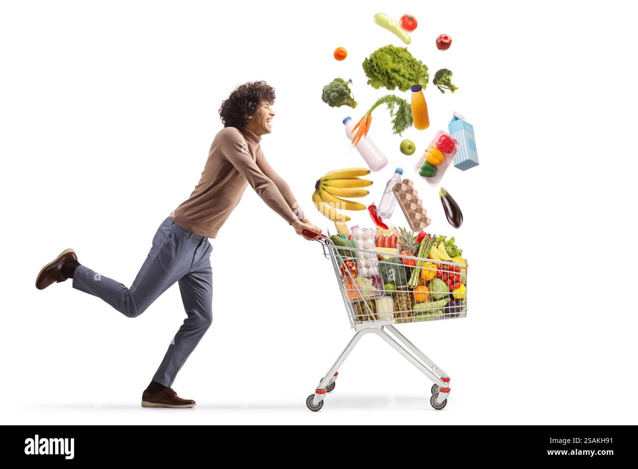Young man running with different products falling into a shopping cart ...