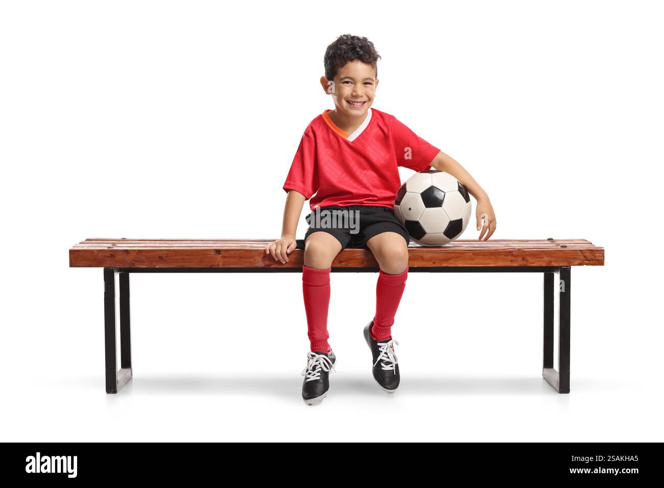 Smiling boy sitting on a bench with a football isolated on white ...