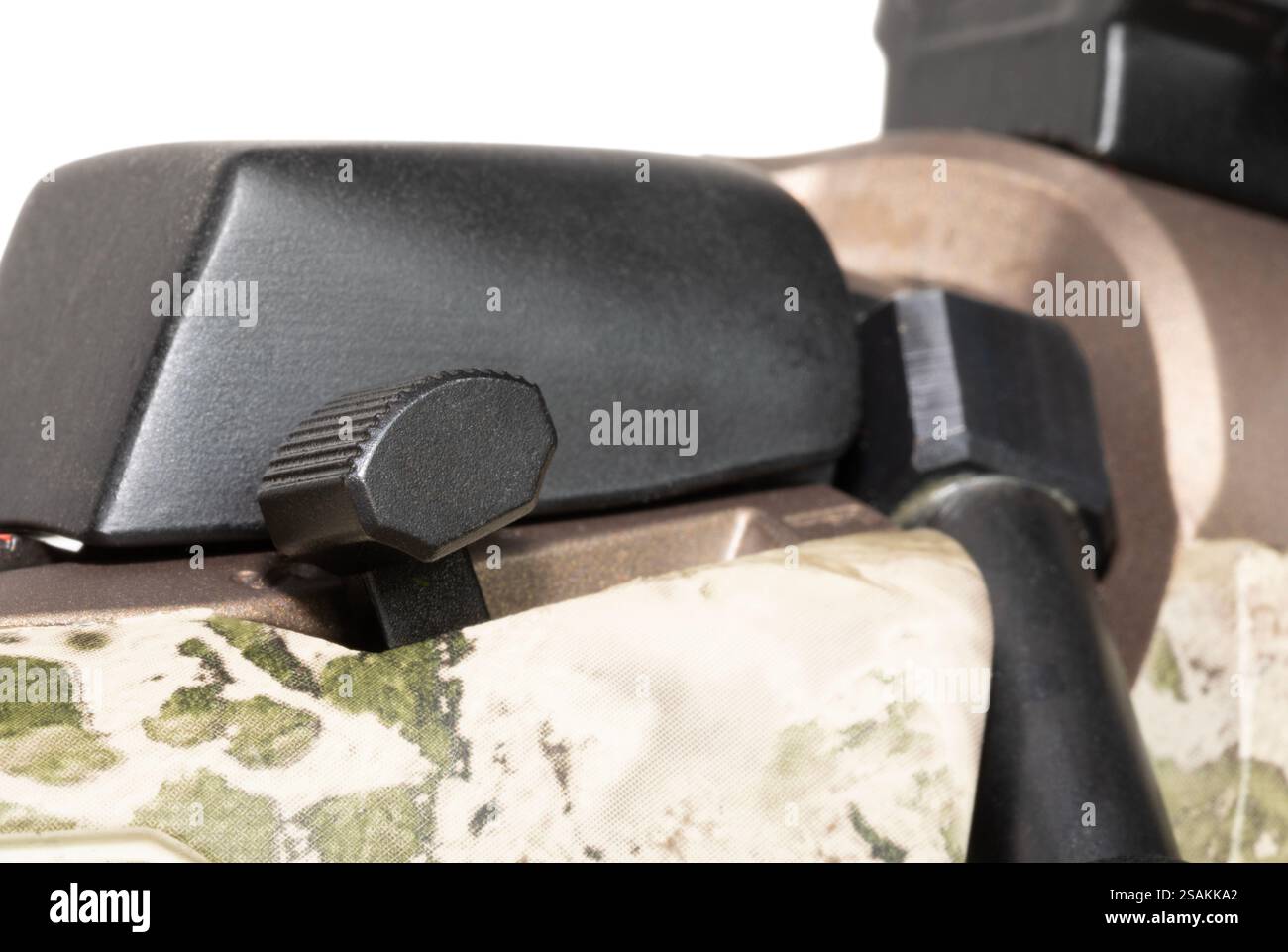 Black safety switch on a bolt action rifle with a camouflage stock ...