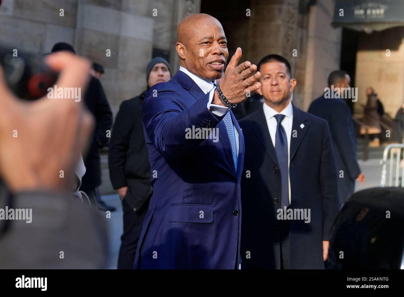 New York City mayor Eric Adams, center, talks to someone as he leaves ...