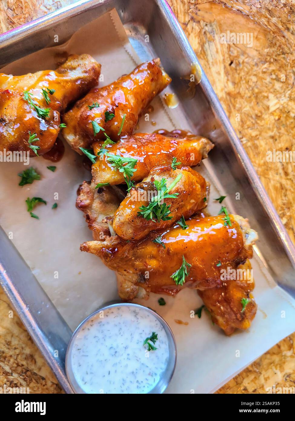 Glazed Chicken Wings with Herb Dip on Rustic Tray Eye-Level View Stock ...