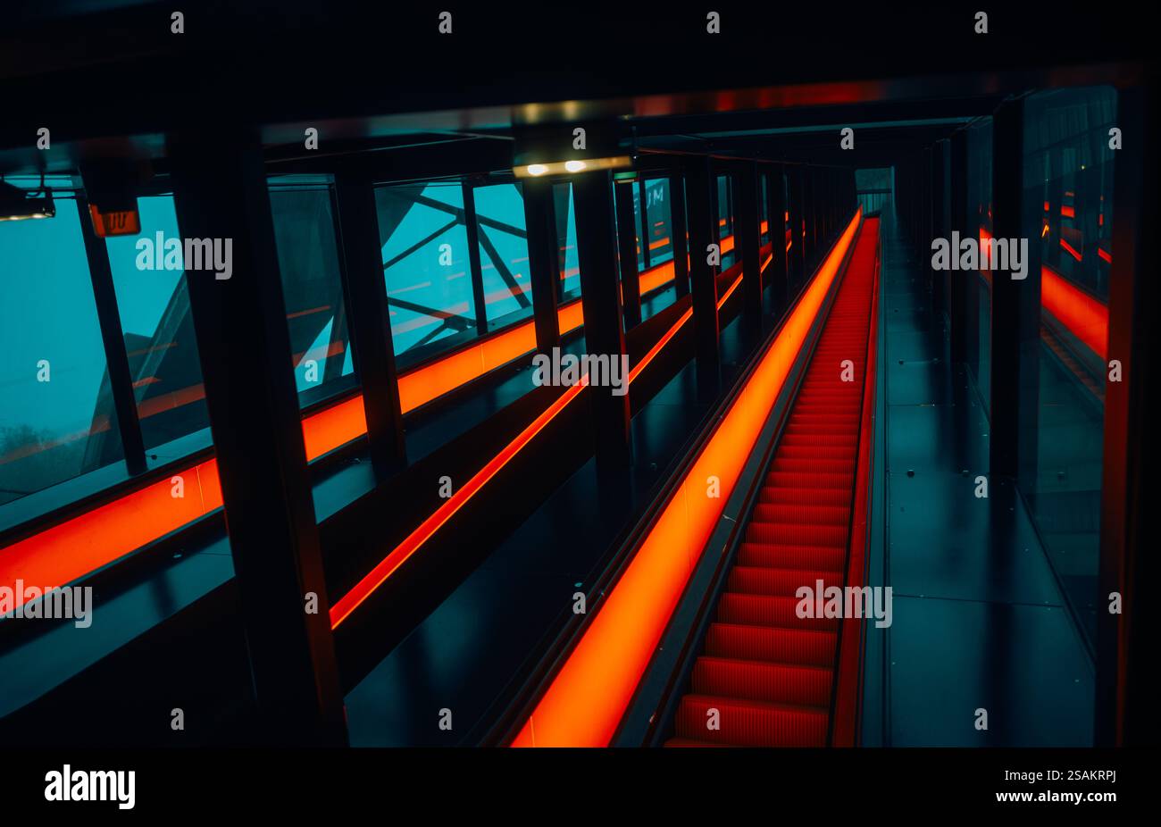 A striking red escalator inside a modern, futuristic glass structure ...