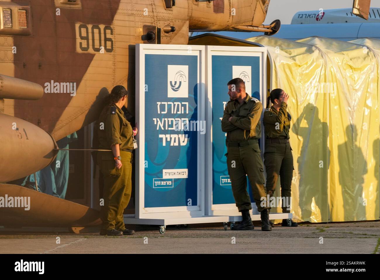 Israeli soldiers stand next to an Israeli military helicopter carrying ...