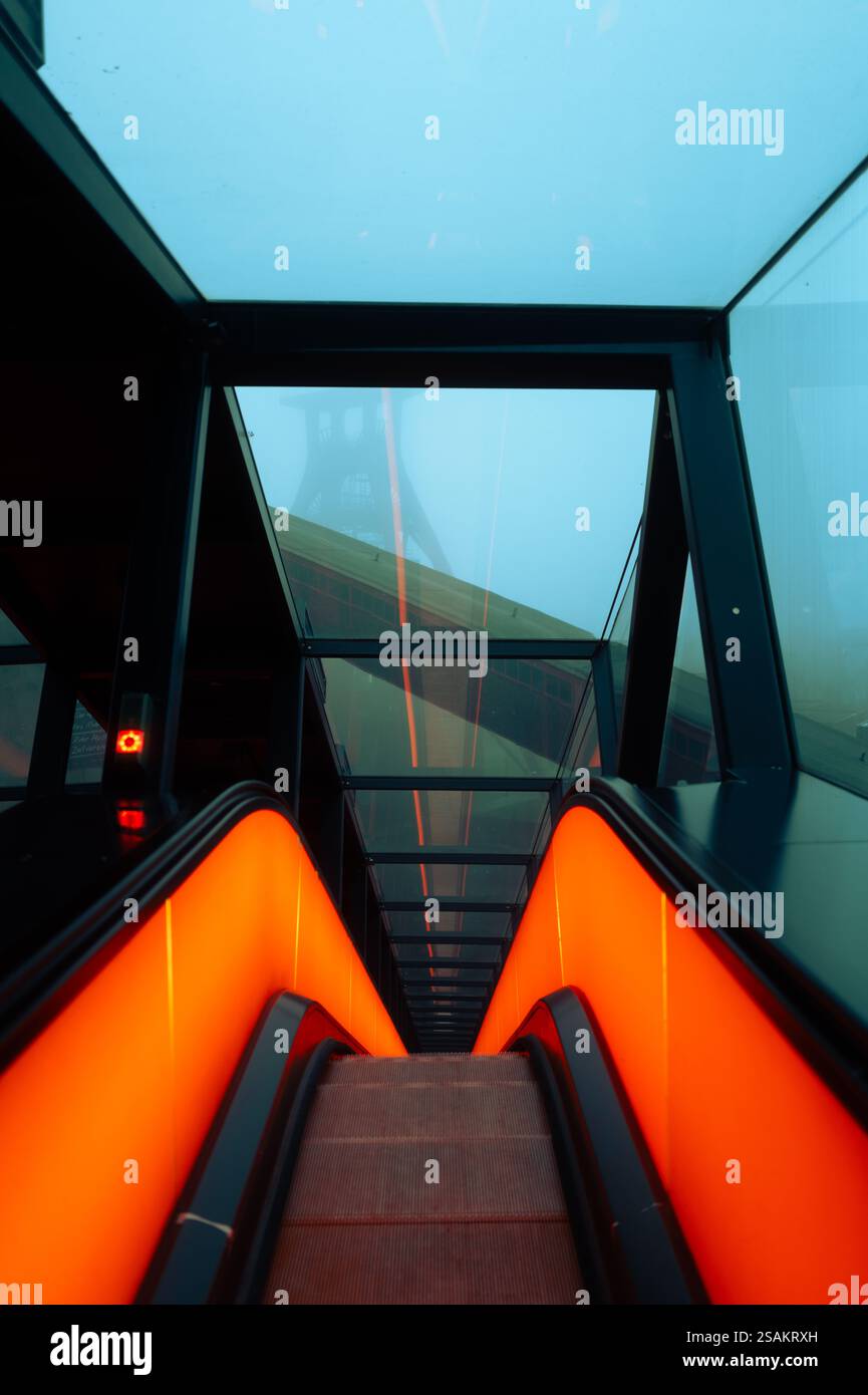 A futuristic escalator with bright red lights leading upwards inside a ...