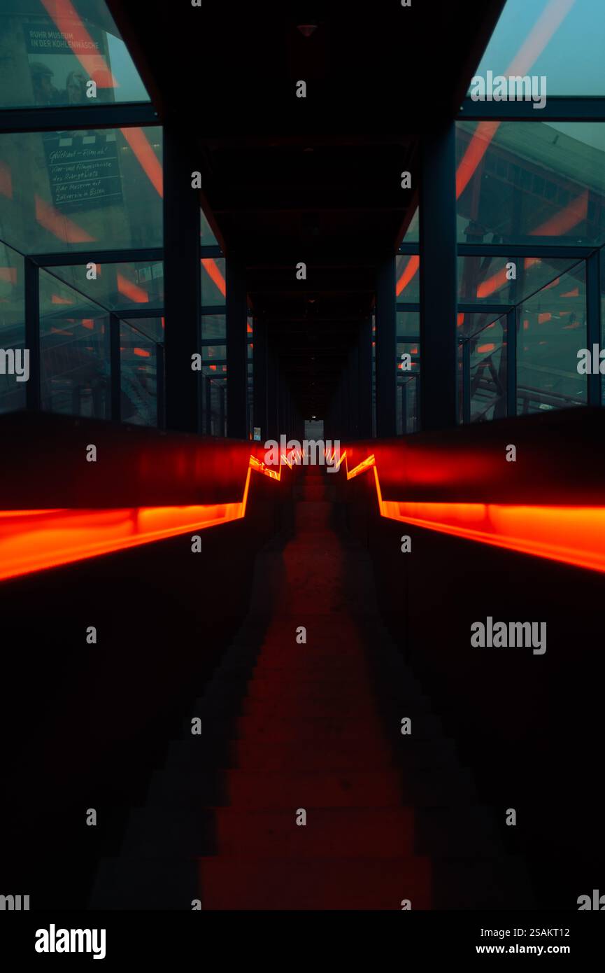 A striking view of a glowing red escalator at Zollverein, framed by ...