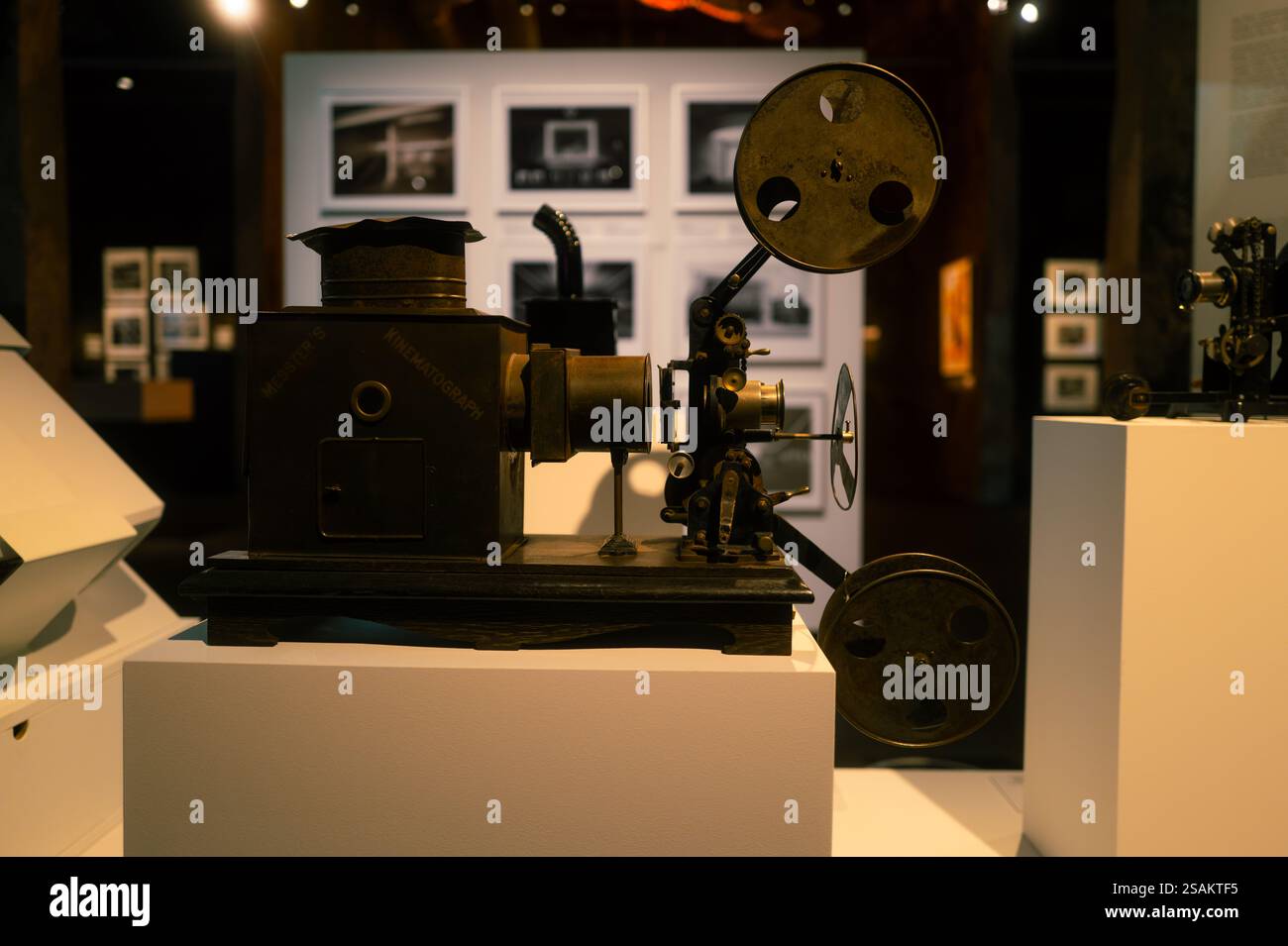 Antique film projector displayed in a museum with vintage photographs ...