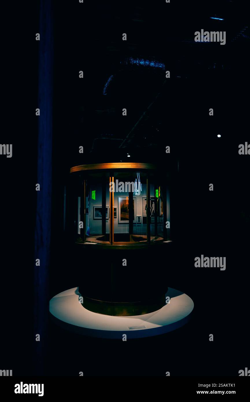 A futuristic glass ticket booth illuminated by blue neon lights in a ...