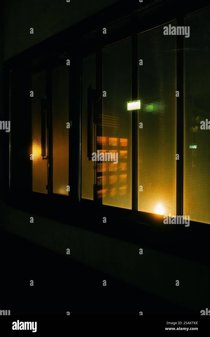 Abstract night shot of illuminated glass windows with reflections of ...