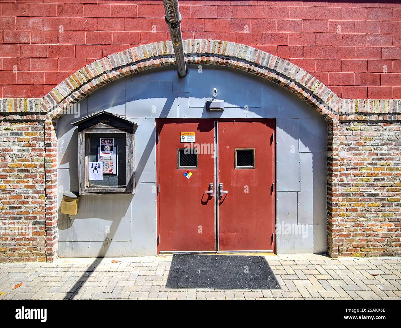 Red Double Doors with Community Board in Urban Brick Facade Eye-Level ...