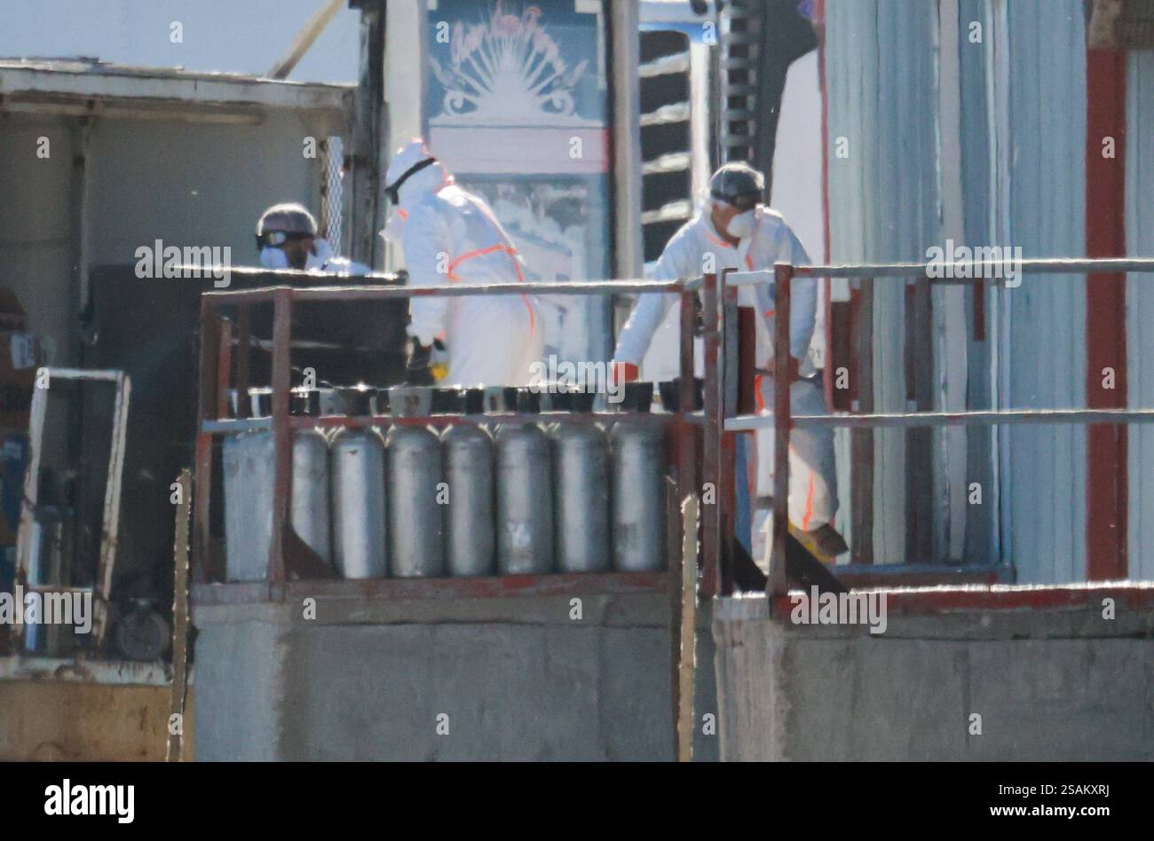 Workers carry gas containers into a chicken coop at the Rose Acre Farms ...