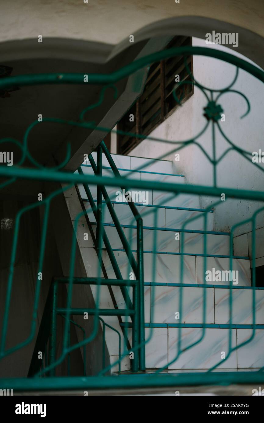 View of a staircase through a green railing, adding a sense of depth ...