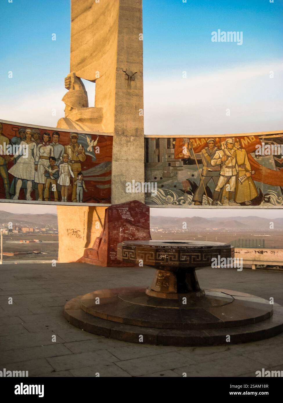 A large stone pillar with a round base and a small pedestal with a ...