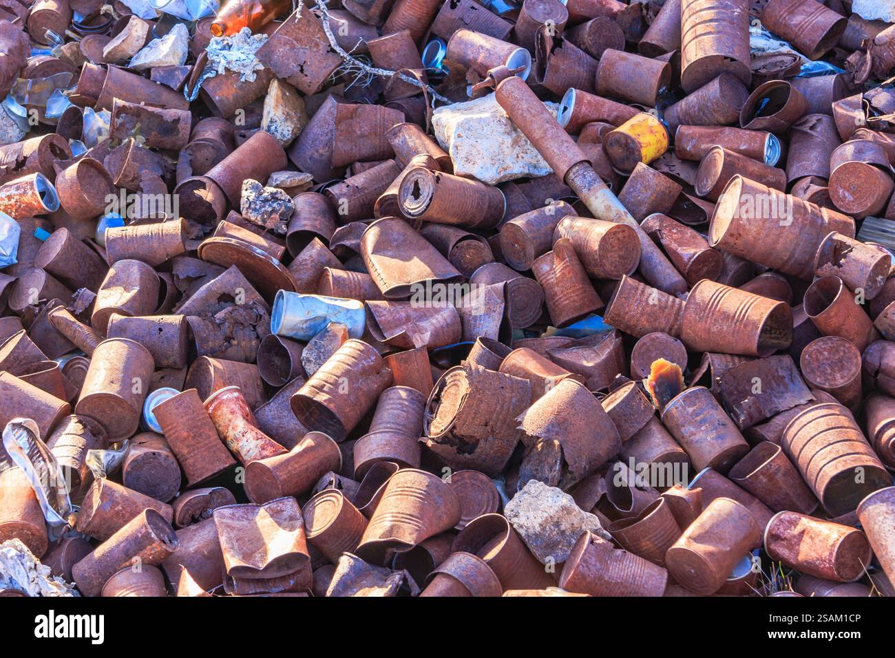 A pile of rusty cans and bottles. The pile is full of trash and is ...
