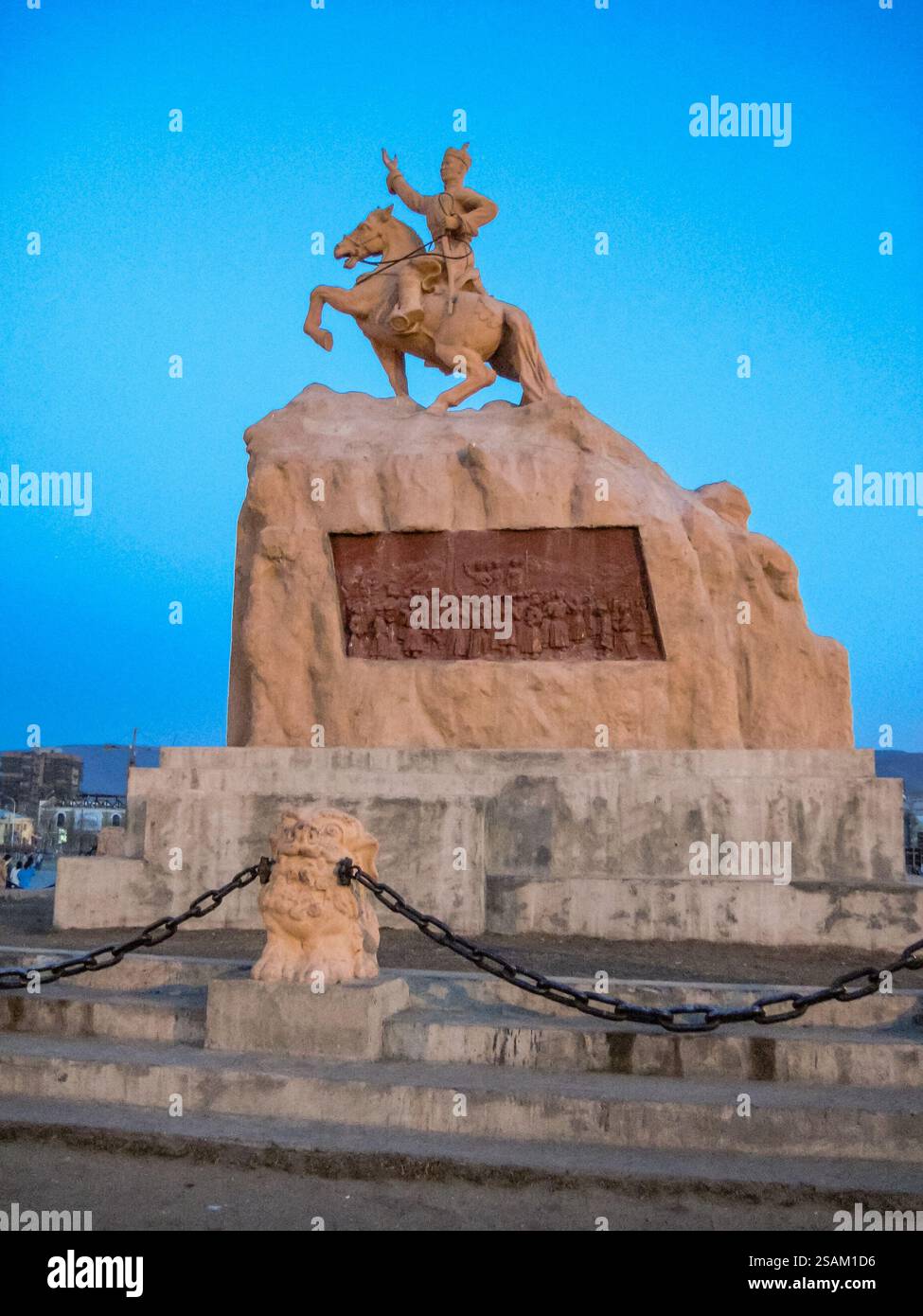 A statue of a man riding a horse on a rock. The statue is surrounded by ...