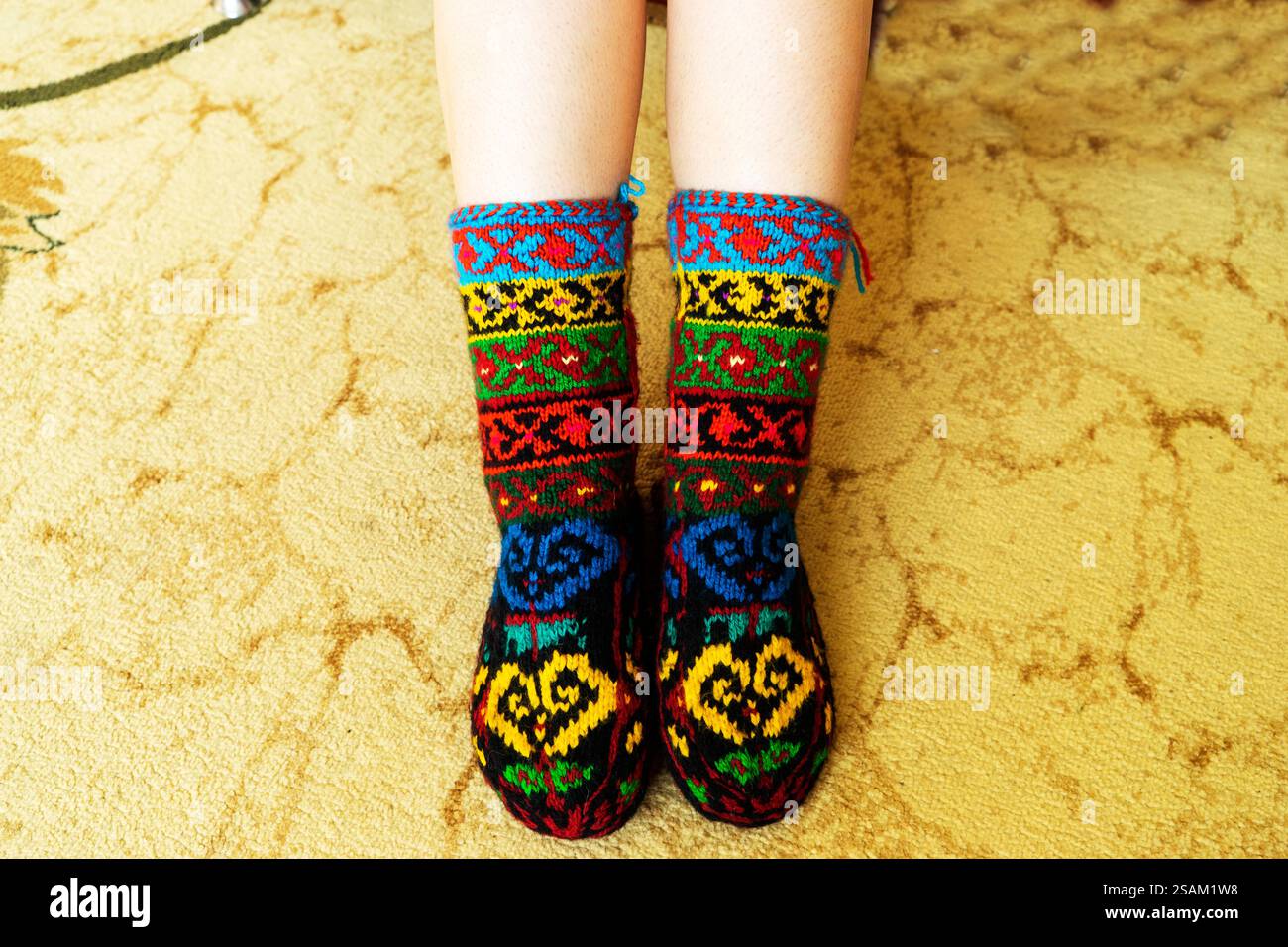 Beautiful wool socks made of multicolored threads on the girl's feet ...