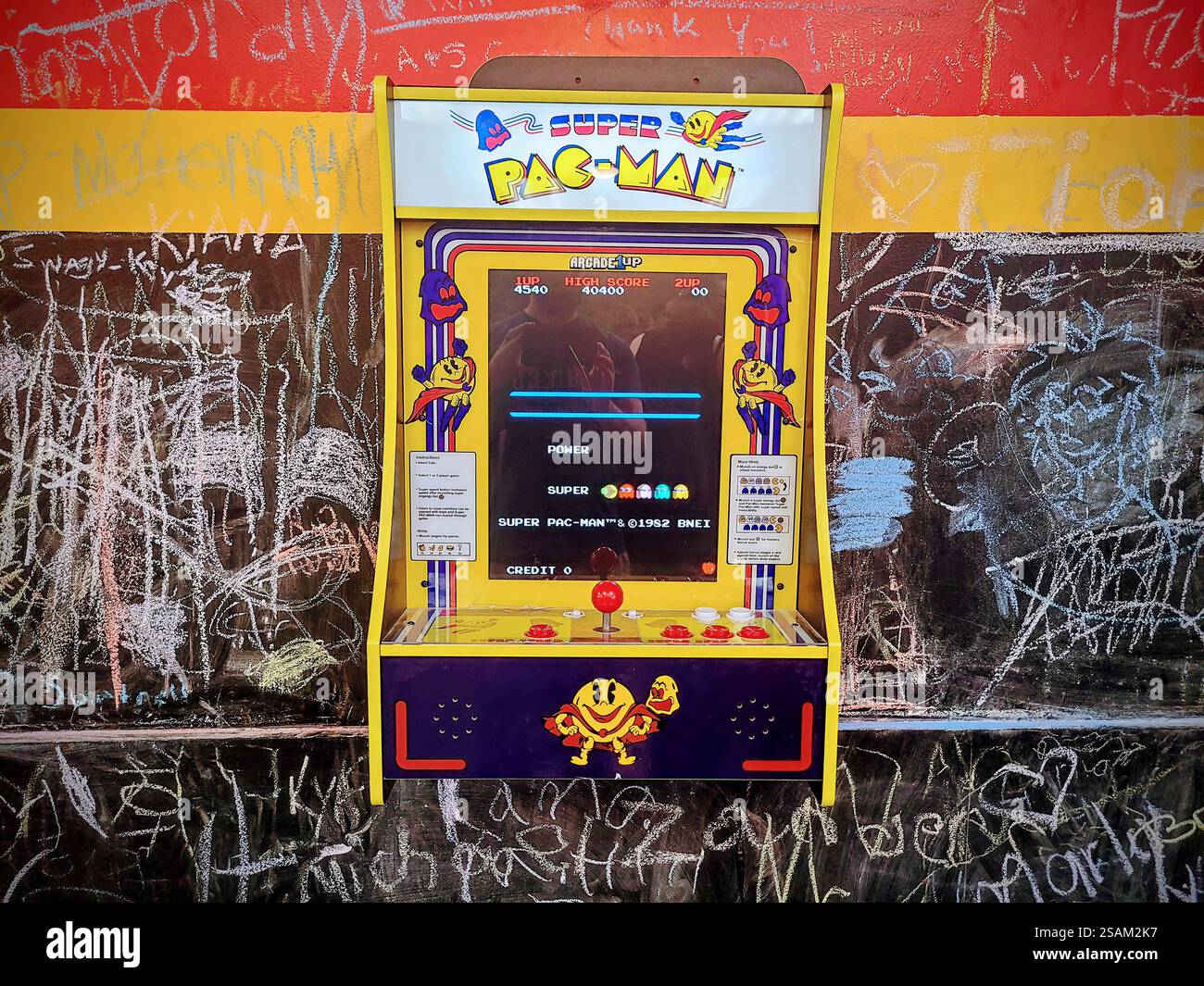 Vintage Super Pac-Man Arcade with Chalk Art Backdrop Eye Level View ...