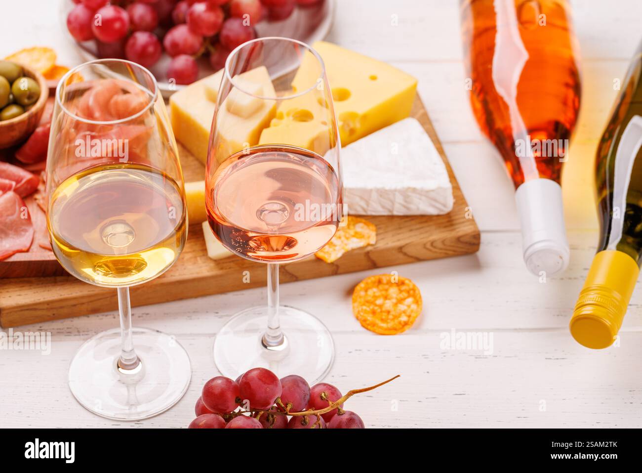 A delectable arrangement of various cheeses, fresh grapes, prosciutto ...