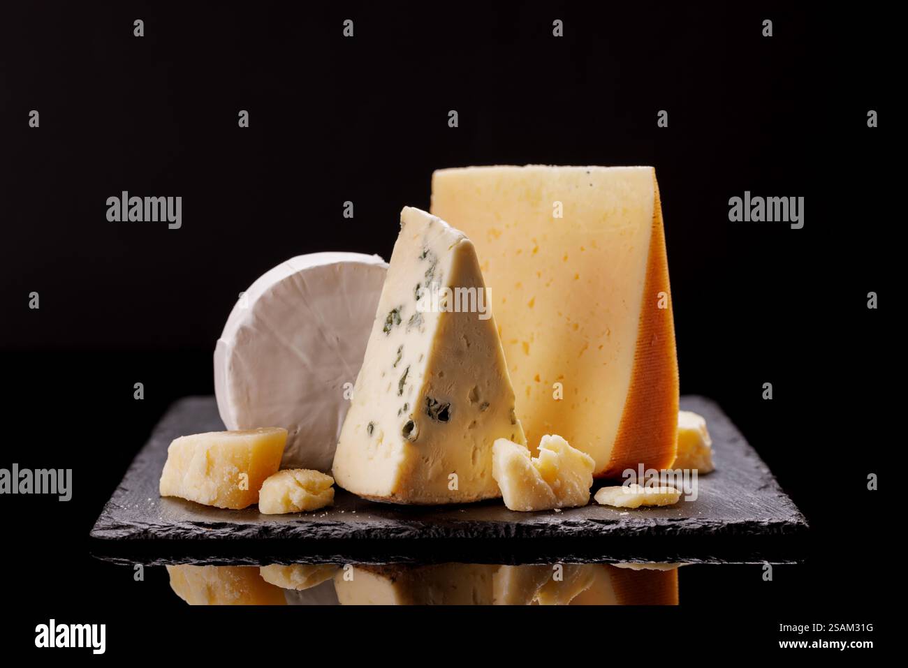 A refined selection of aged cheeses presented on a board, set against a ...