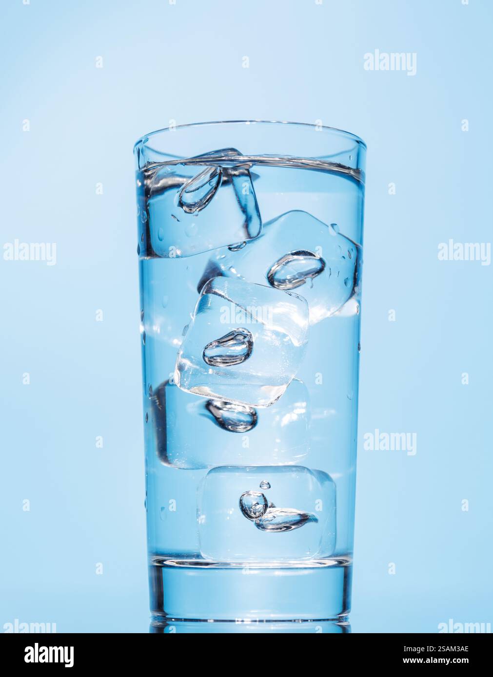 A clear glass filled with chilled water and ice cubes, creating a ...