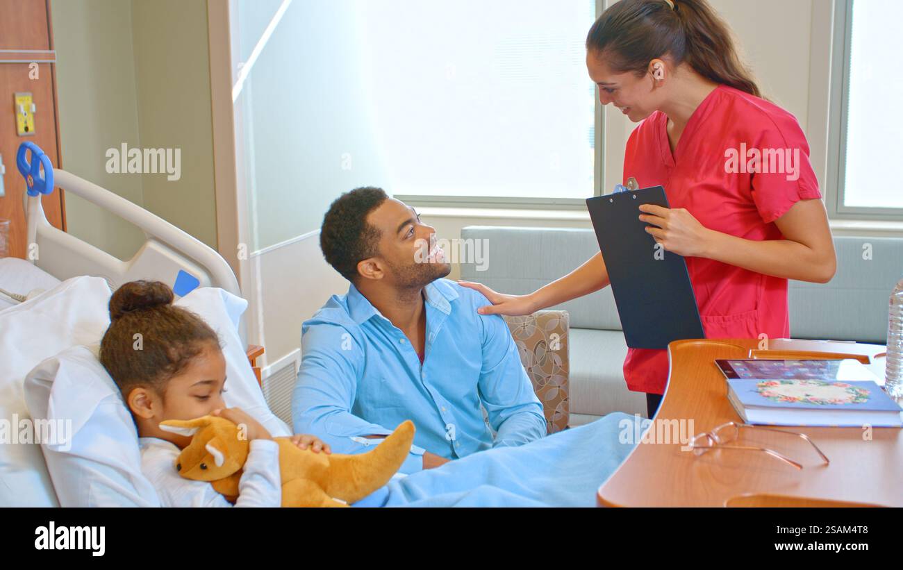 Female Doctor Or Nurse Wearing Scrubs Meeting With Father Visiting ...