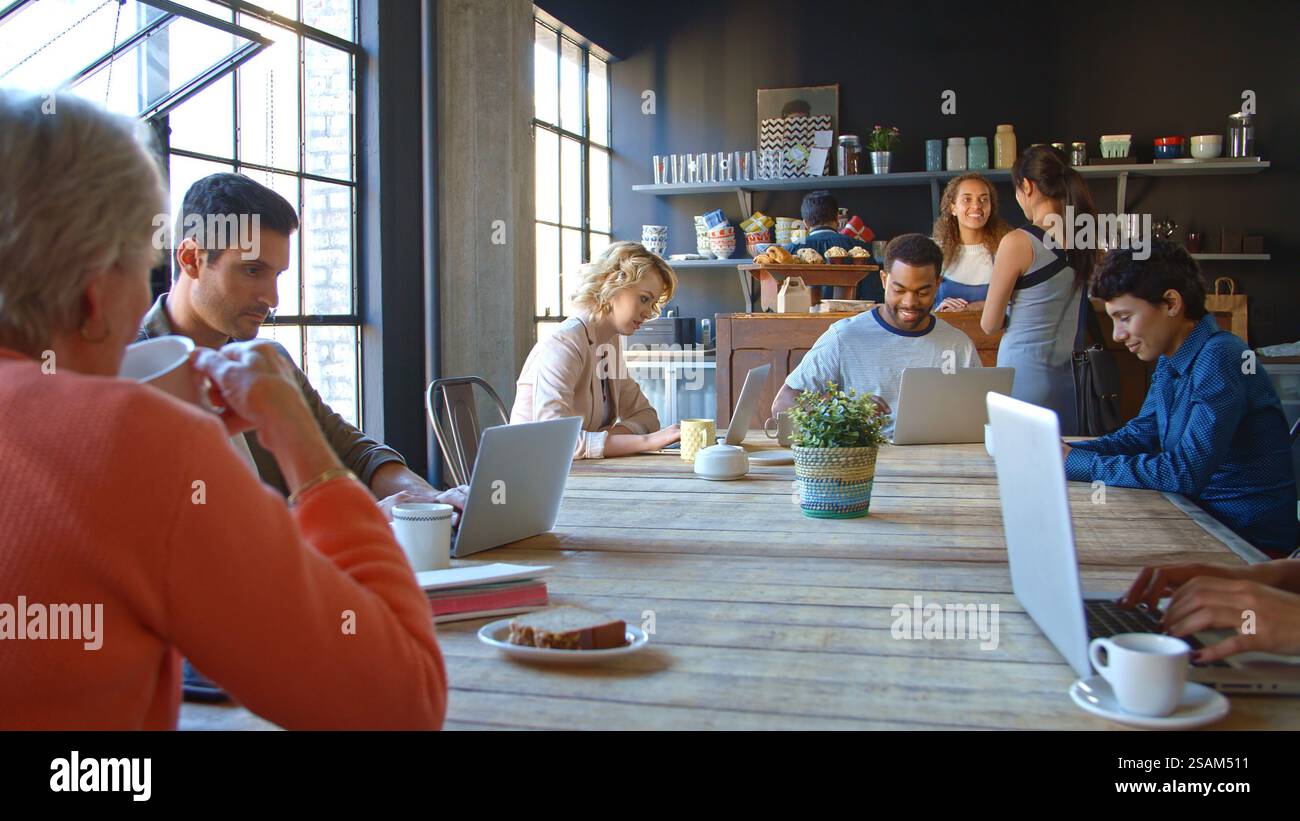 Interior Of Busy Coffee Shop With Business Customers Sitting At Tables ...
