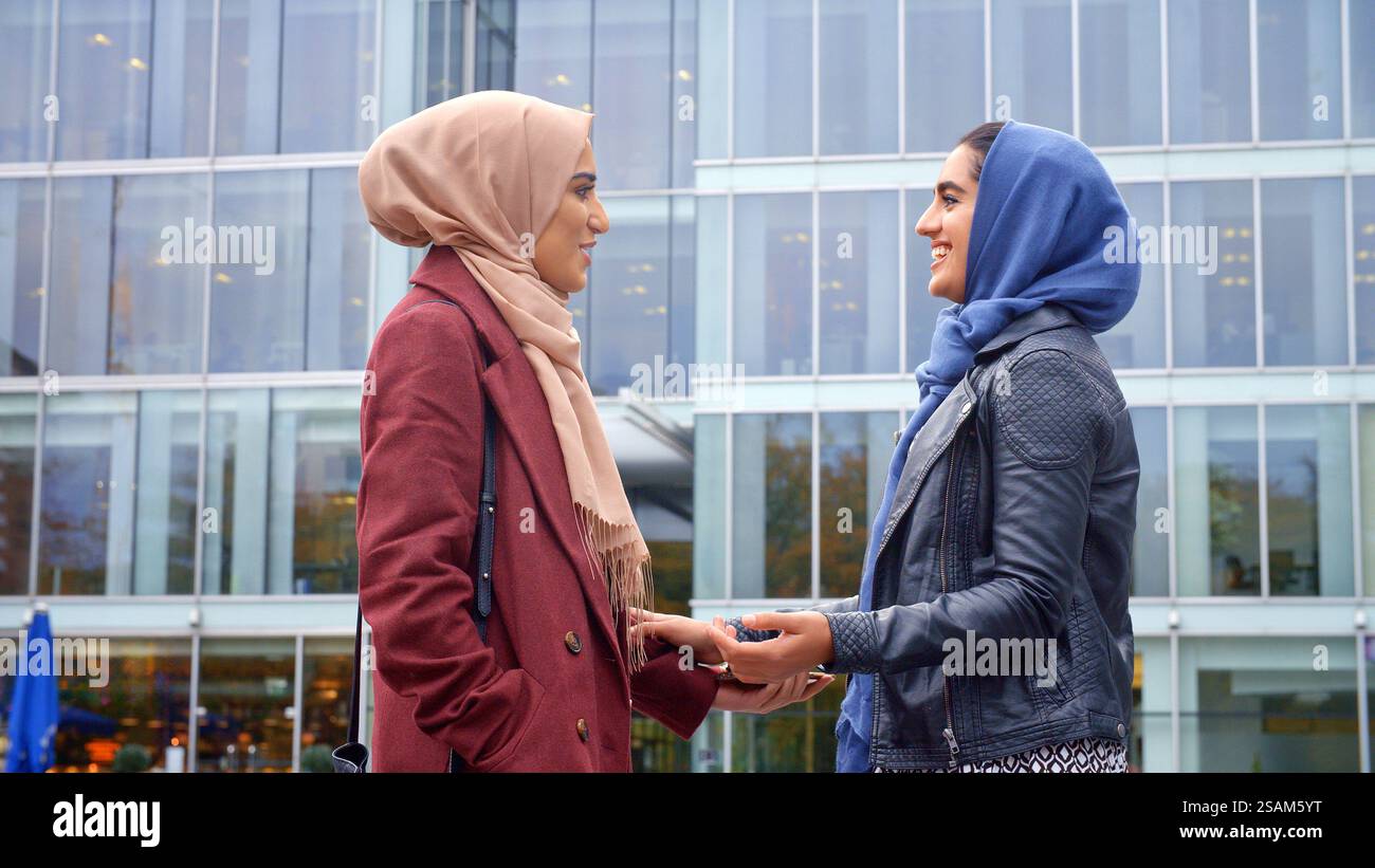 Two British Muslim Women Friends Wearing Hijabs Meeting Outside Office ...