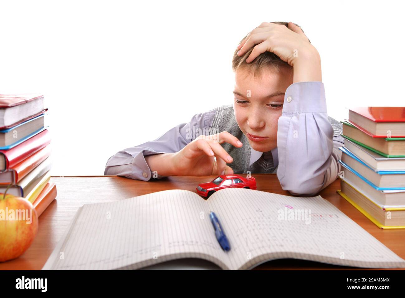 Bored Kid plays with a Toy on the School Desk on the white background ...