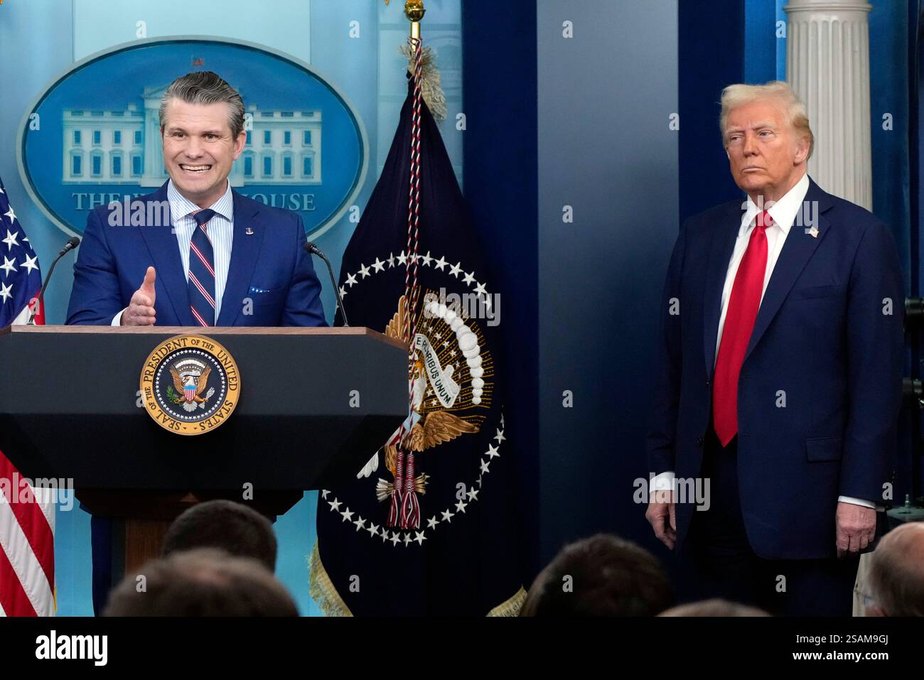 President Donald Trump listens as Defense Secretary Pete Hegseth speaks ...