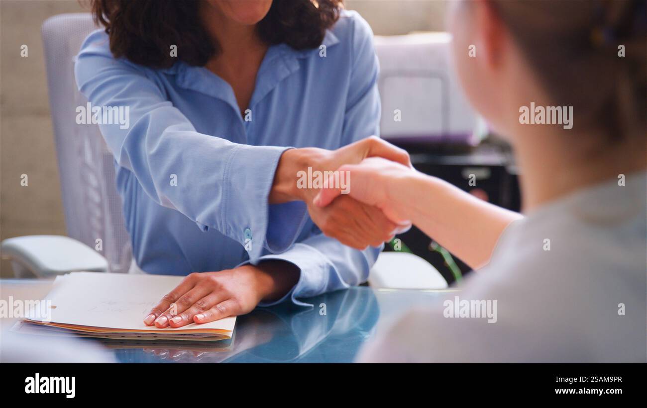 Close Up Of Businesswoman Behind Desk Shaking Hands With Female ...