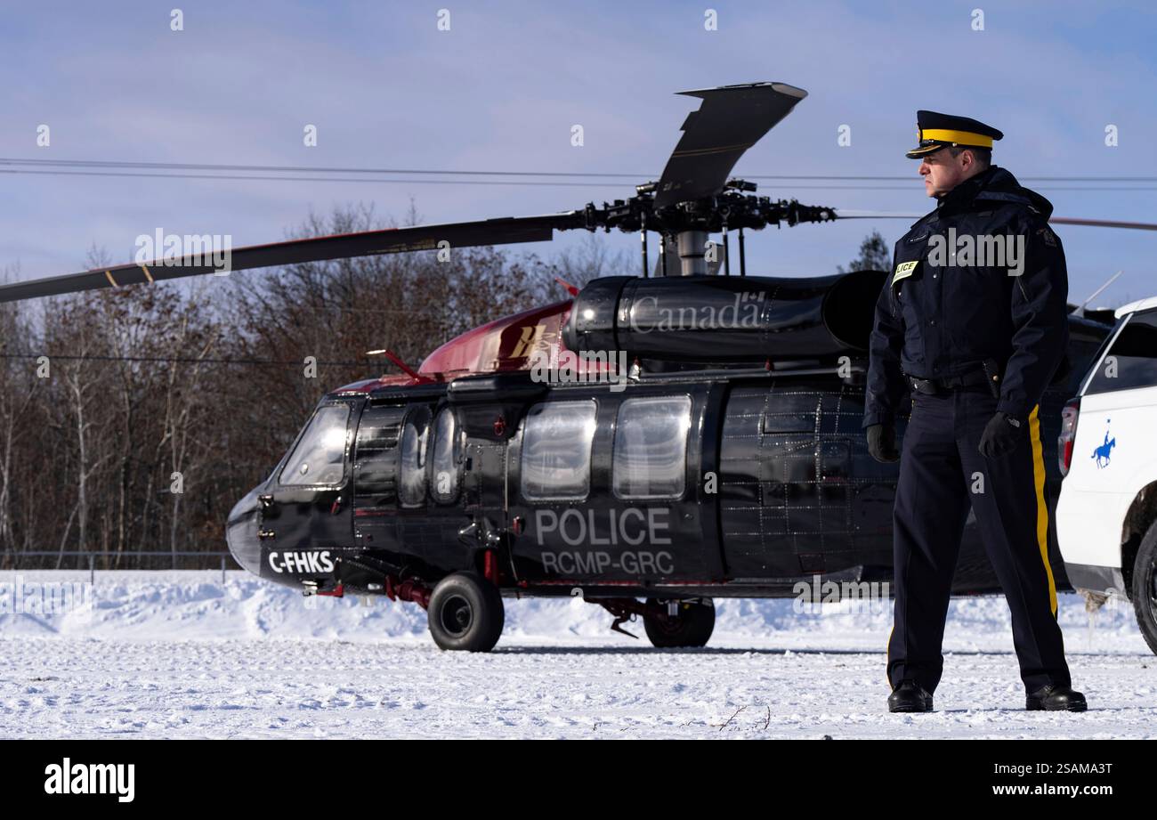 A Royal Canadian Mounted Police (RCMP) officer looks over their new ...