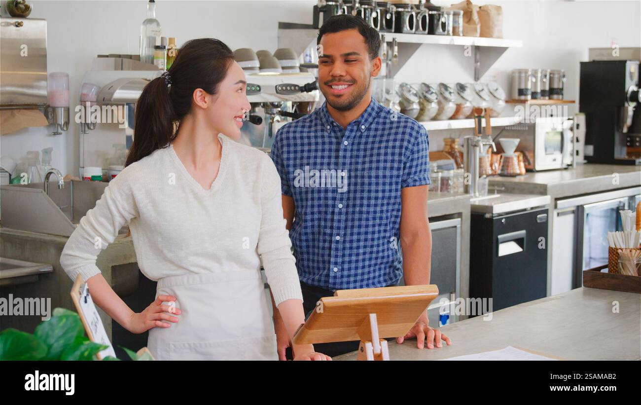 Smiling Male And Female Owners Or Workers Behind Counter In Coffee Shop ...
