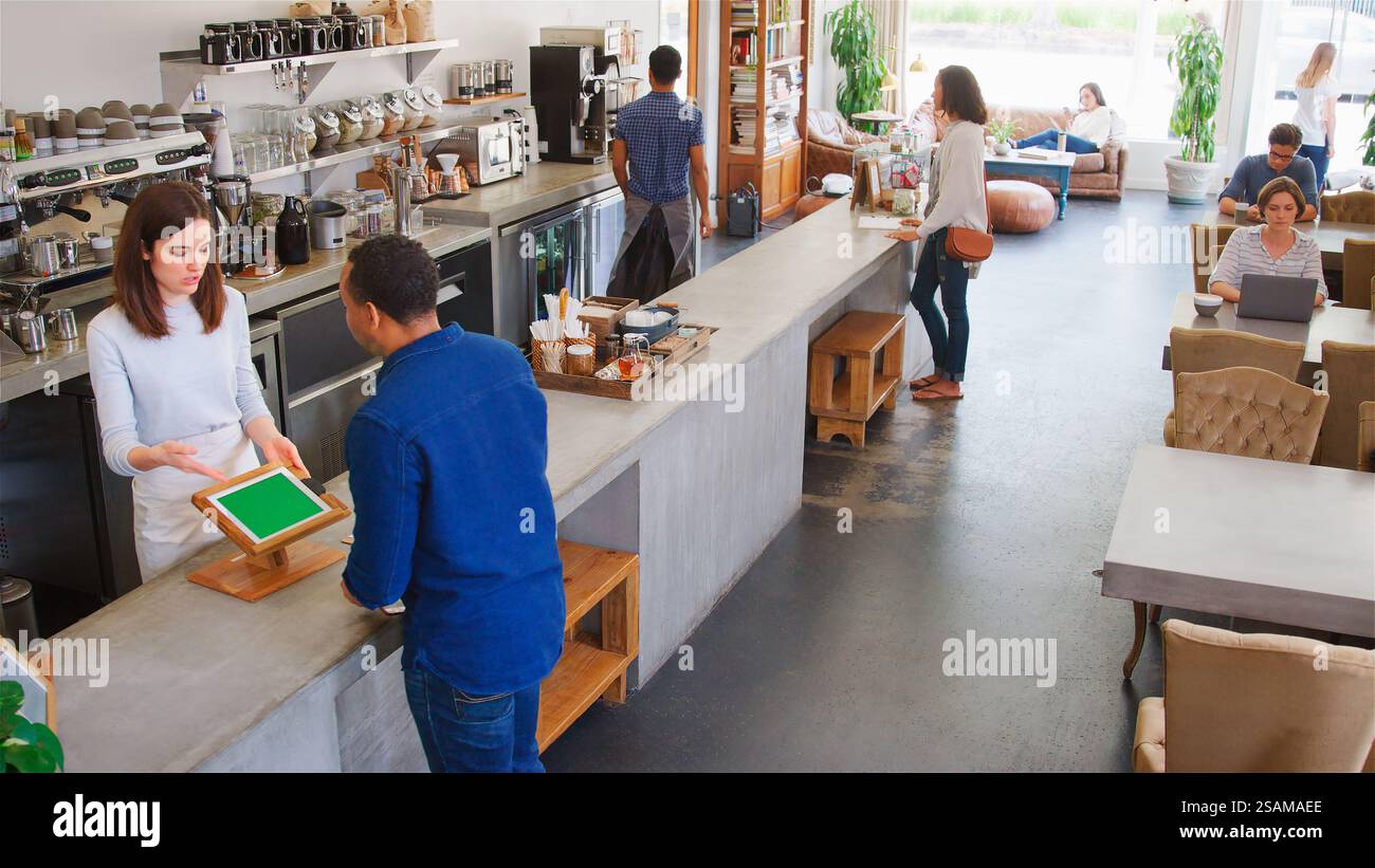 Interior Of Busy Cafe Or Coffee Shop With Staff Serving Customers At ...