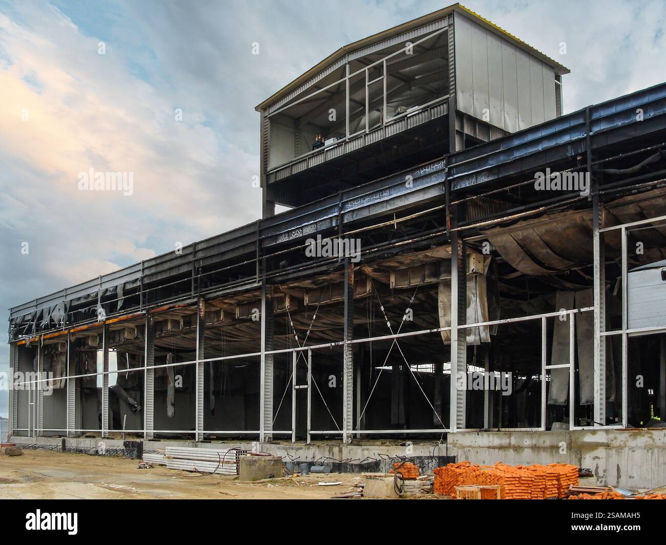 Burned industrial warehouse under construction with fire damage visible ...
