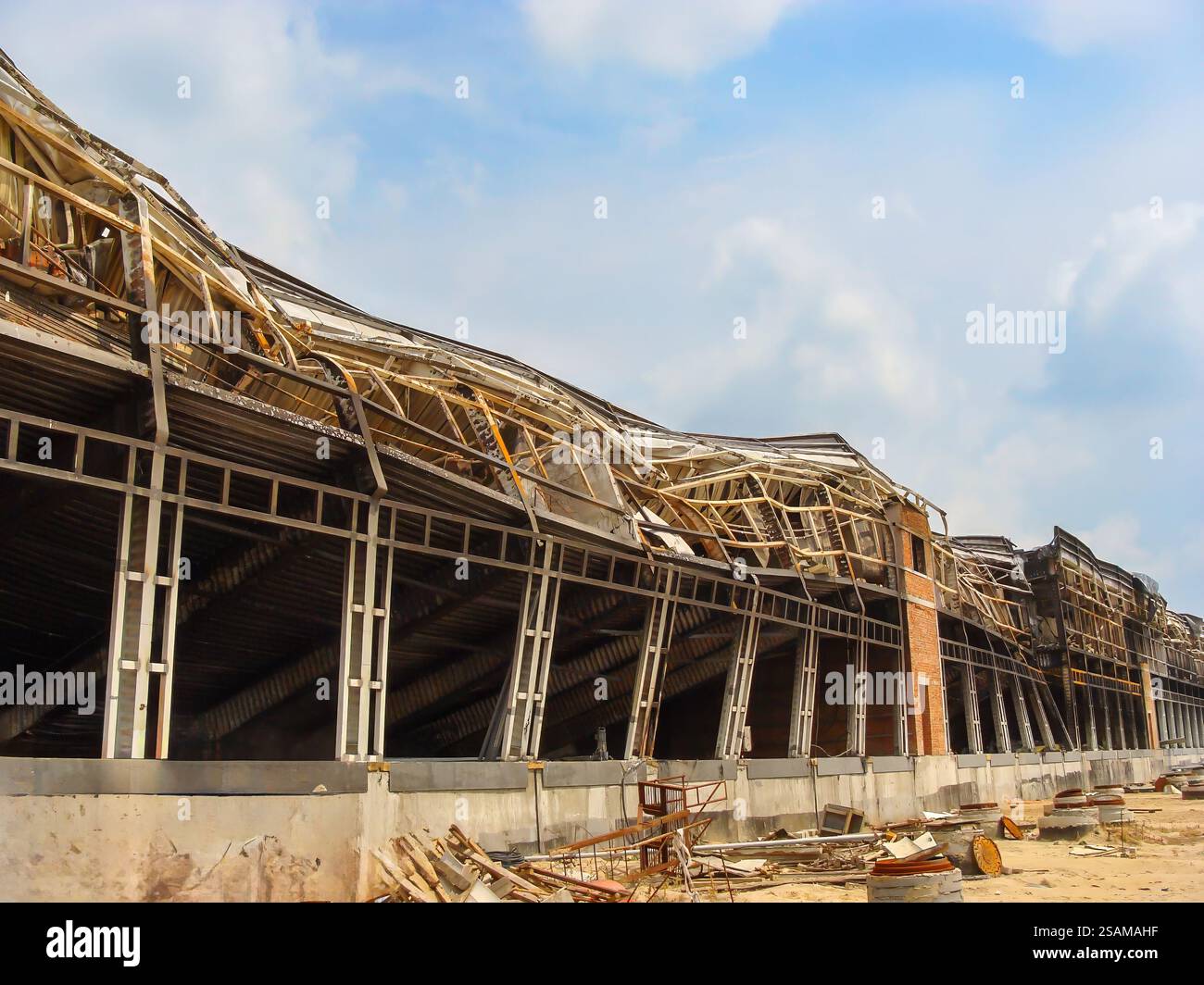 Large fire-damaged storage building with collapsed structure and ...