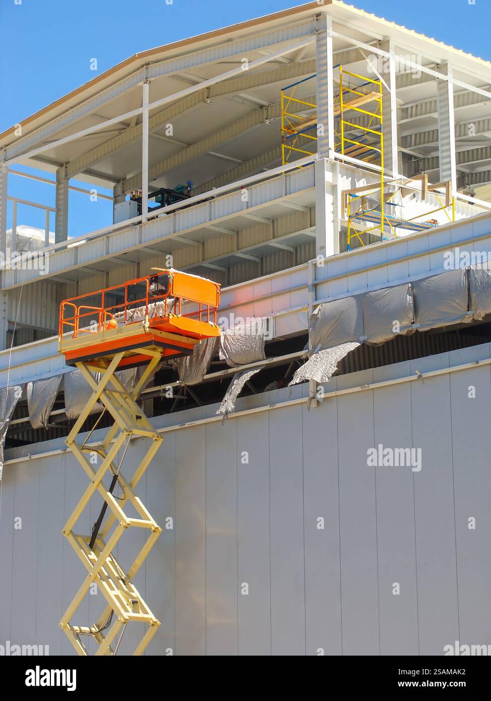 Industrial cold storage under construction with scissor lift in use ...