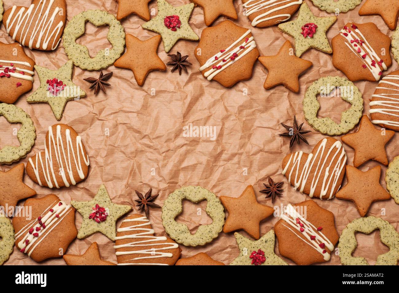 Festive cookies with icing decorations forming a frame on brown ...
