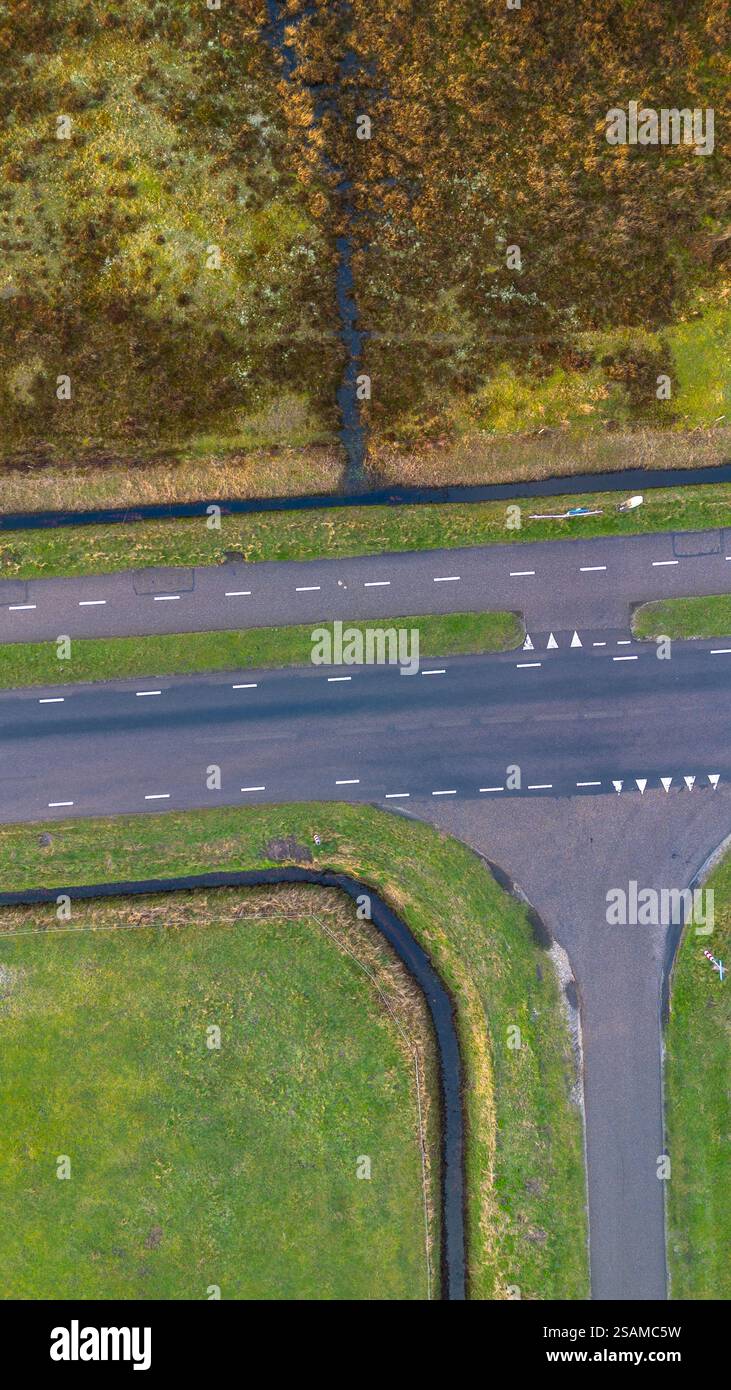 Aerial view of a rural area featuring a straight road with marked lanes ...