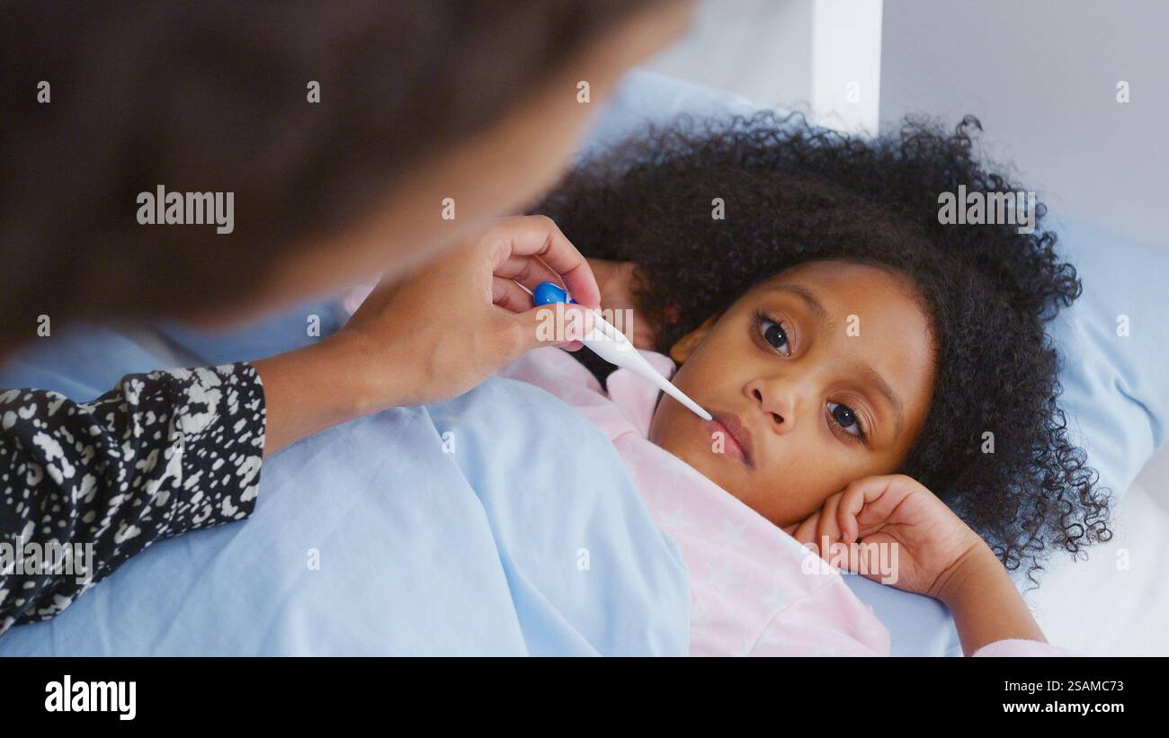 Mother Caring For Sick Daughter Ill In Bed At Home Taking Temperature With Thermometer Stock ...