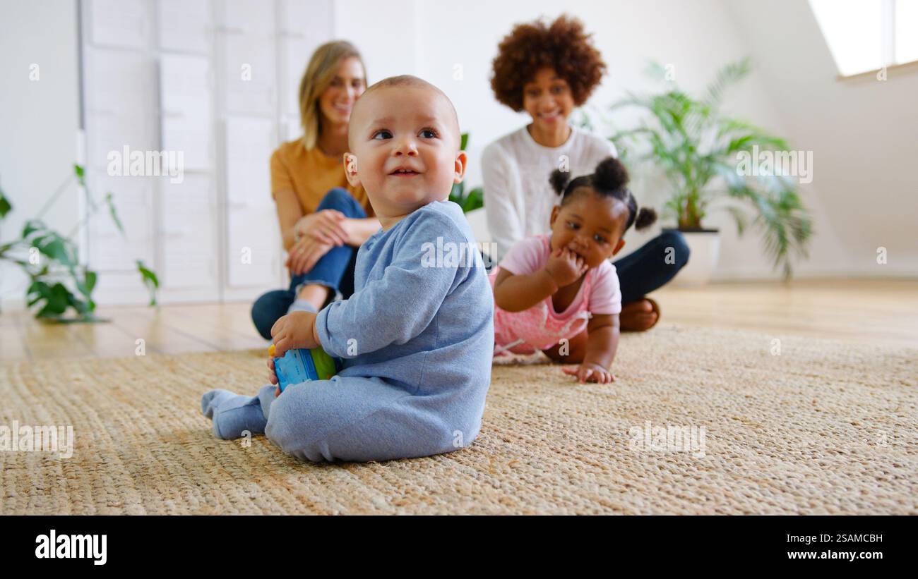 Two Mothers Meeting For Play Date With Babies At Home In Loft Apartment ...