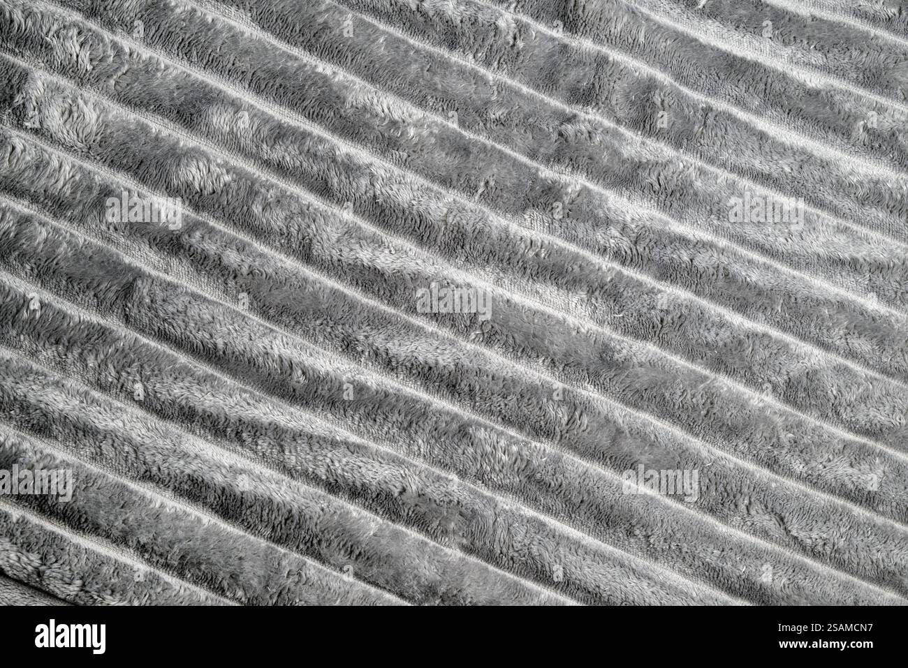 Close up texture of soft, fluffy gray fleece fabric with diagonal folds ...